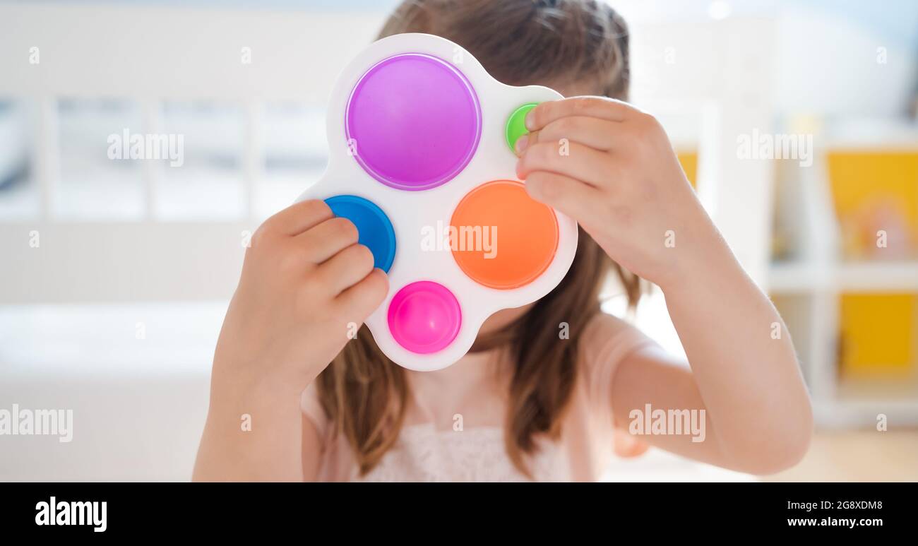 Little girl,kid,child plays with colorful pop it children's room ...