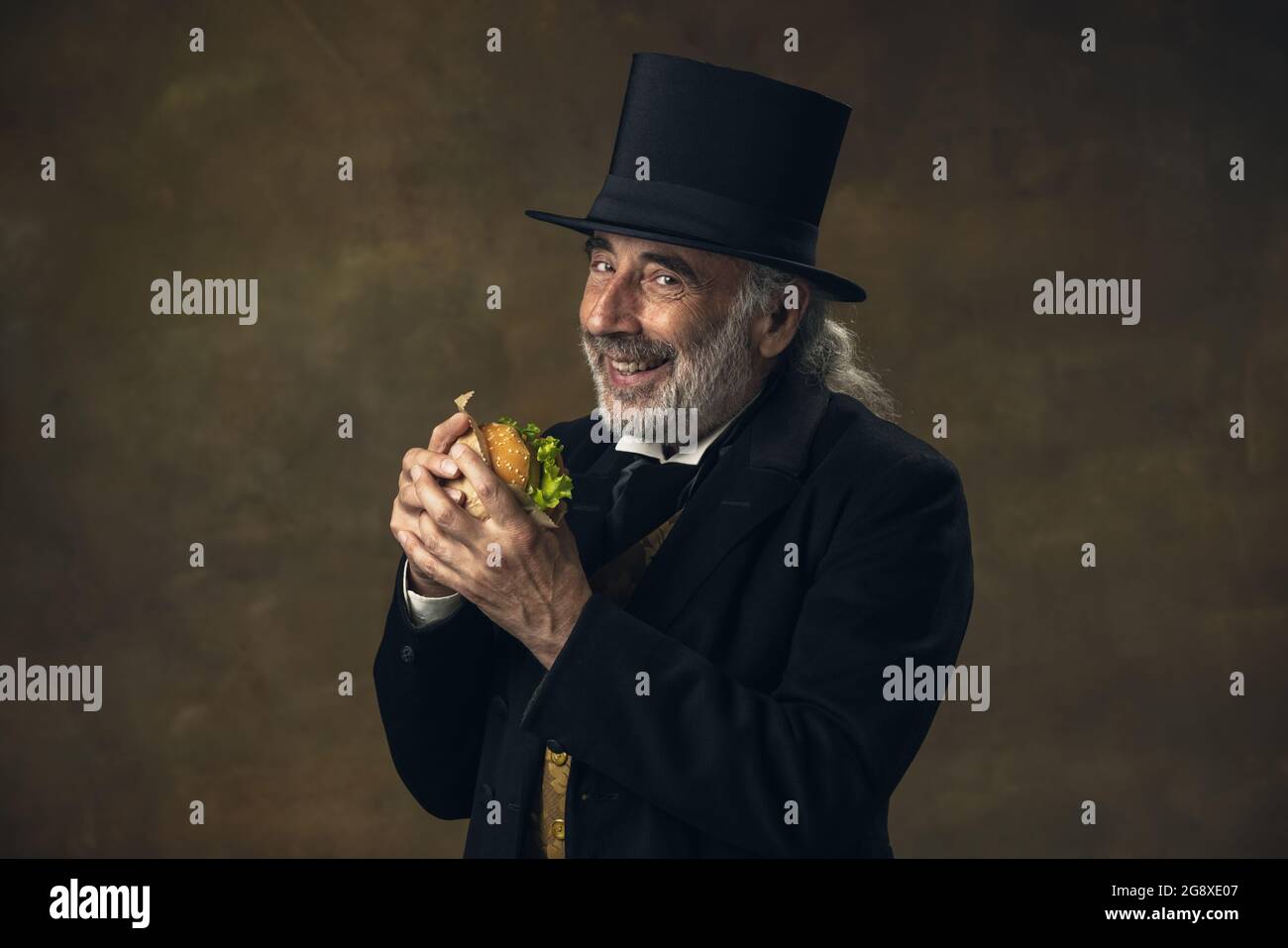 Handsome elderly gray-haired man, gentleman, aristocrat or actor eating ...