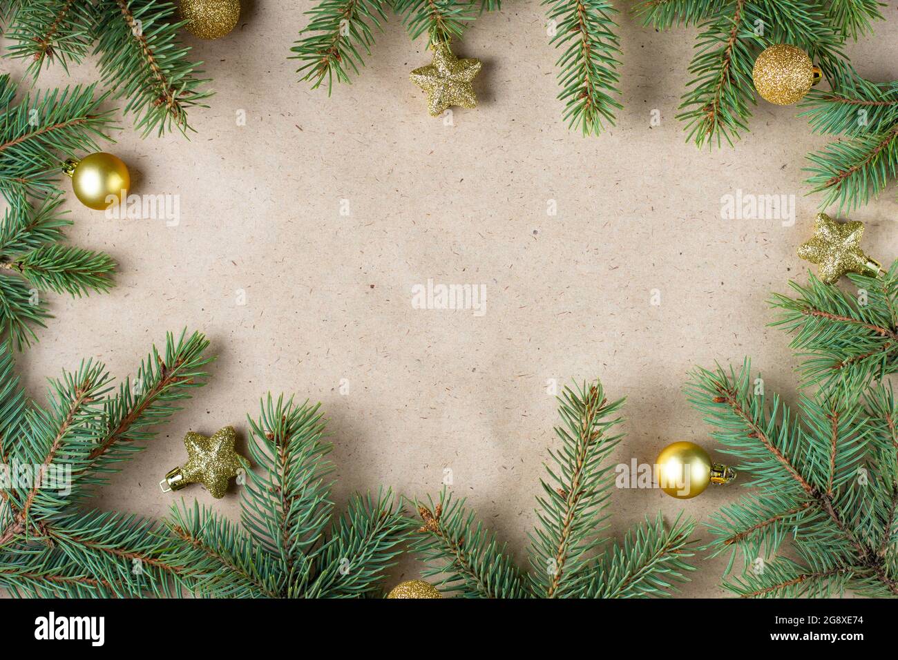 frame of fir tree branch with gold decoration on craft paper for ...