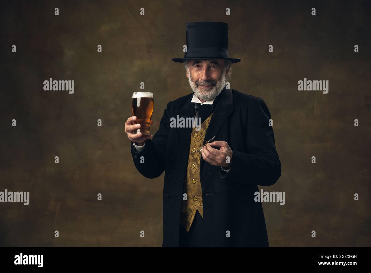 Elderly gray-haired man, gentleman, aristocrat or actor drinking beer ...