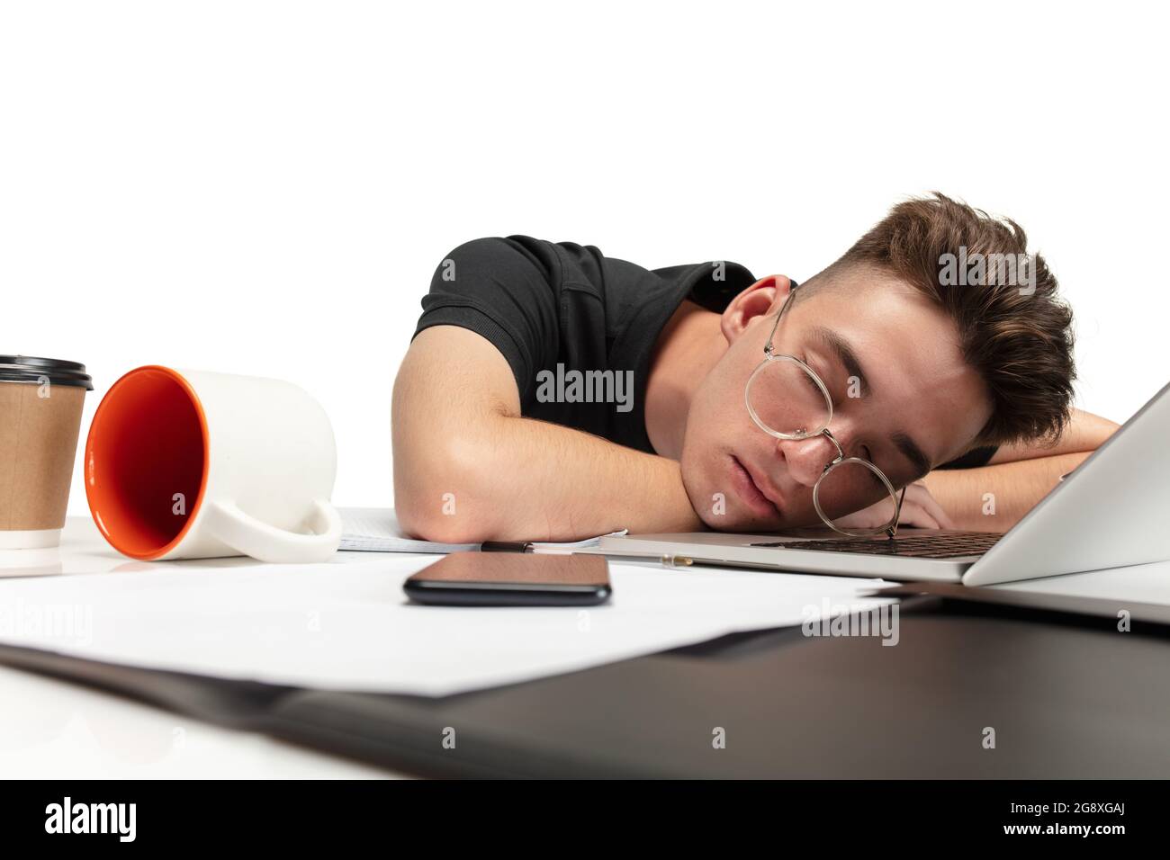 Portrait of one young man, tired student sleeping at table on white ...