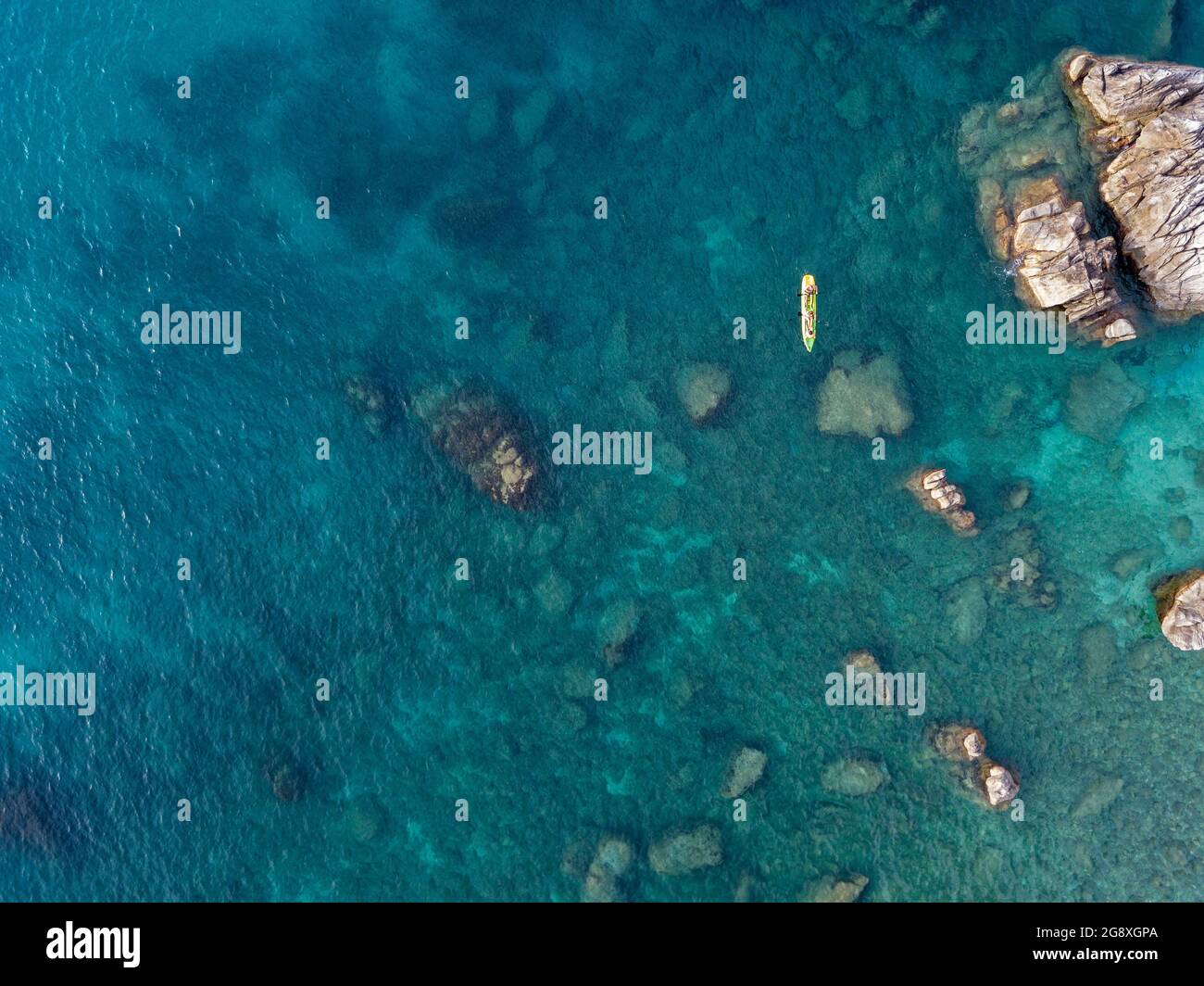 Aerial view of a canoe in the water floating on a transparent sea ...