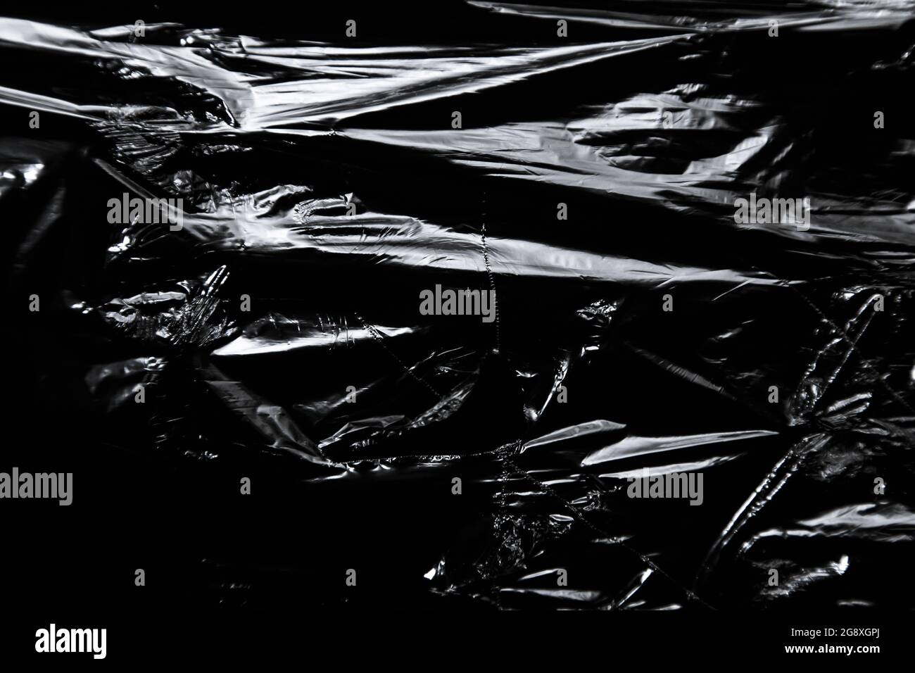 Photo of the polyethylene surface with ragged hole on black background ...