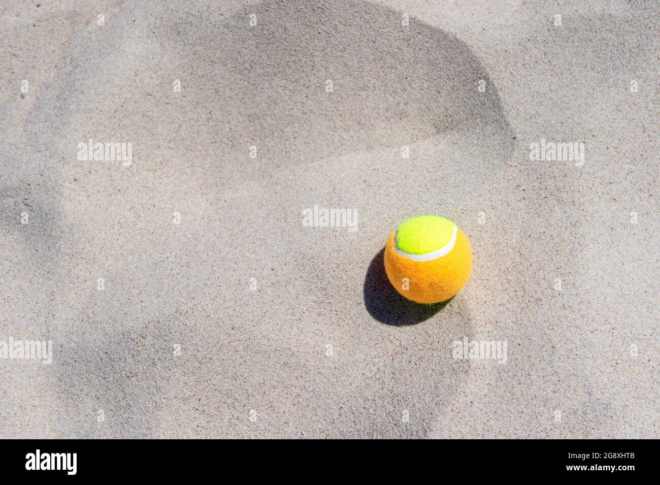 Tennis ball on the sand at the beach close up. Professional sport ...