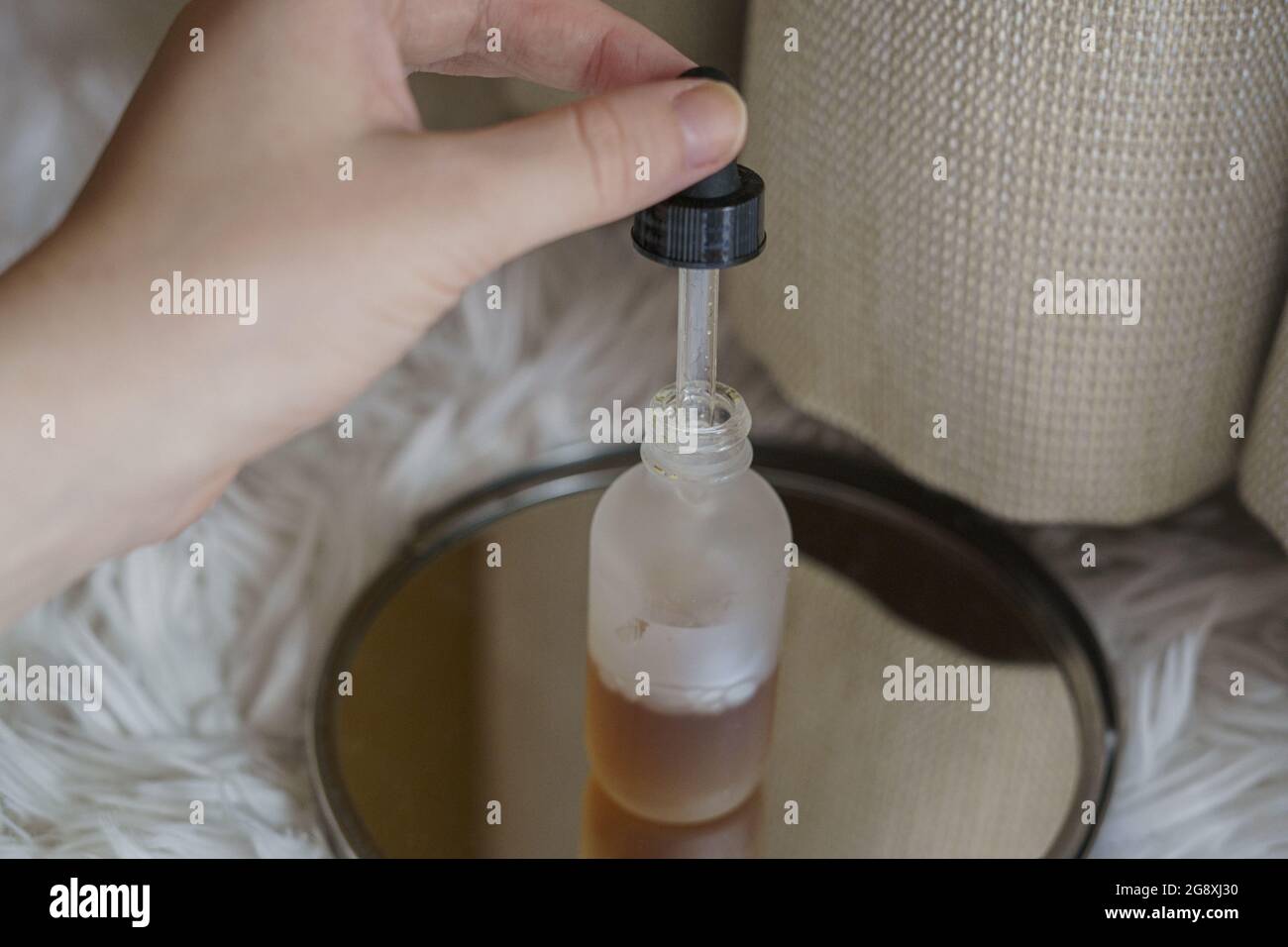 Selective focus shot of a hand holding the dropper of a glass dropper ...