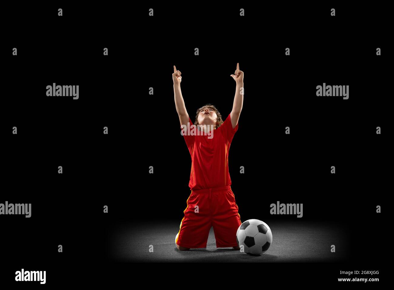 Winner. One little male football soccer player, boy training with ...