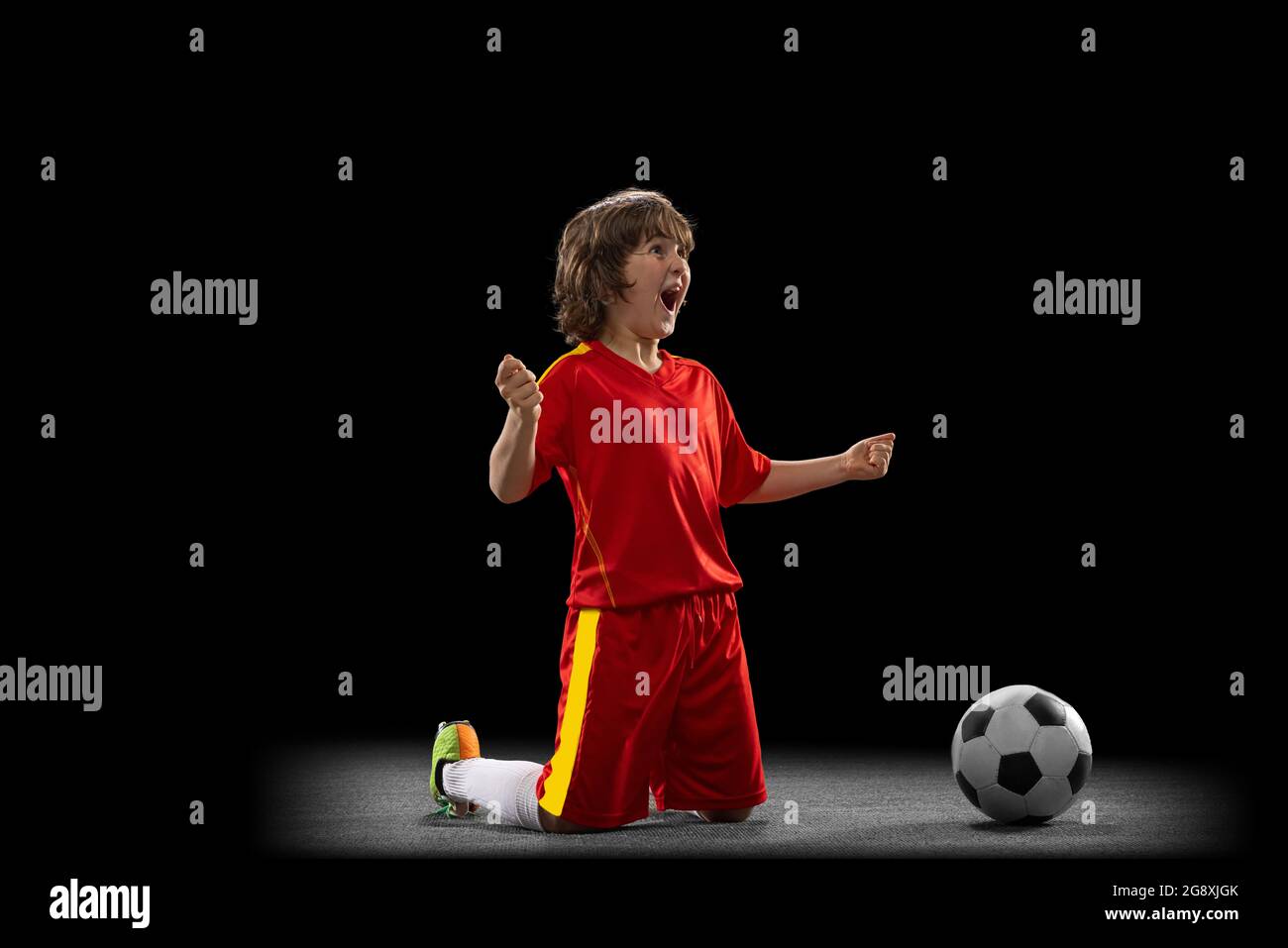 Happy, excited boy, football soccer player in red sports uniform with ...