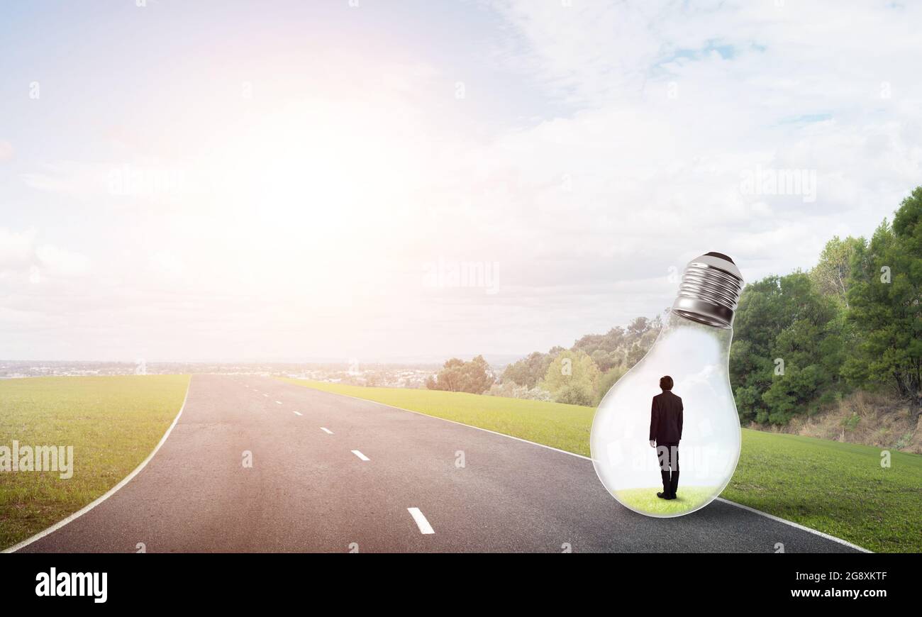 Businessman inside light bulb Stock Photo - Alamy