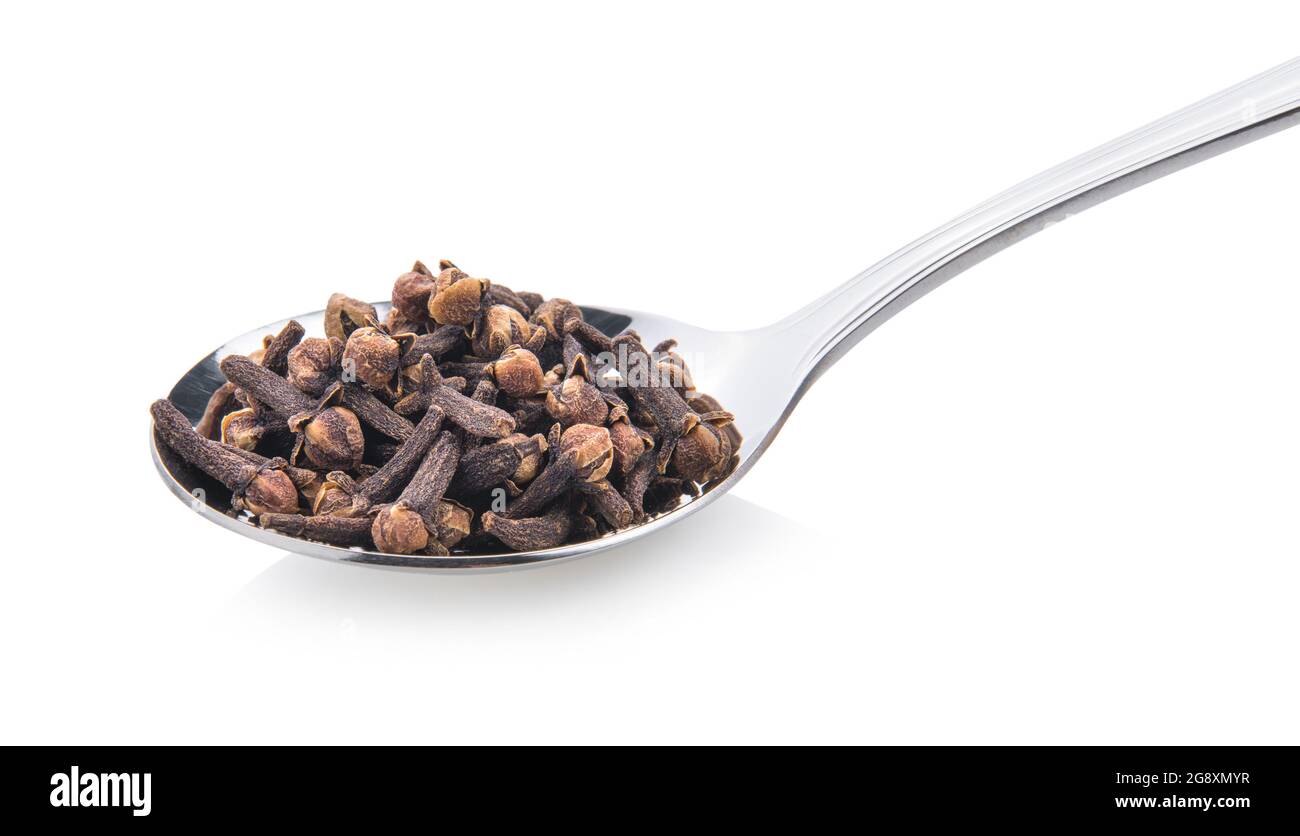 cloves spices in spoon on white background Stock Photo - Alamy
