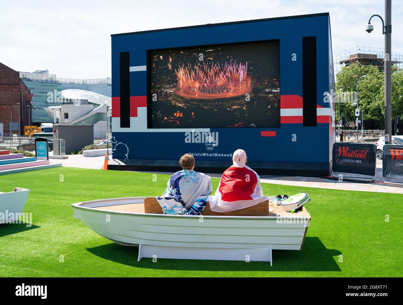 Fans watch the opening ceremony of the Tokyo 2020 Olympic Games on a ...