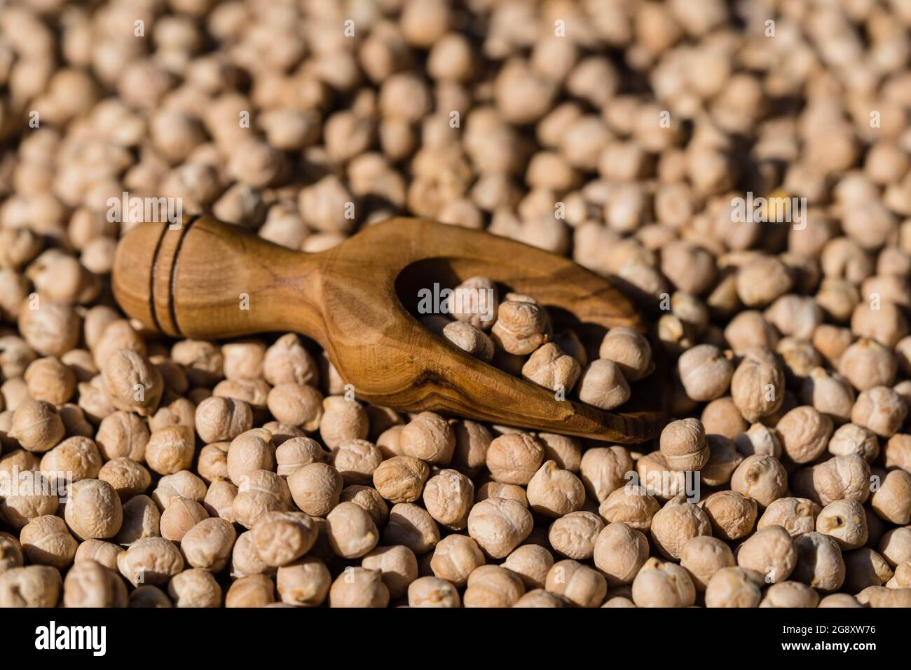 a pile of chick peas and a wooden spoon Stock Photo - Alamy