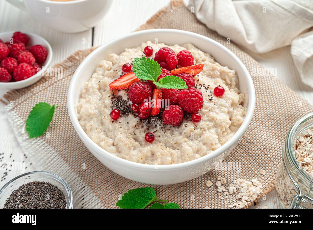 Oatmeal porridge with berries and chia seeds on a light background ...