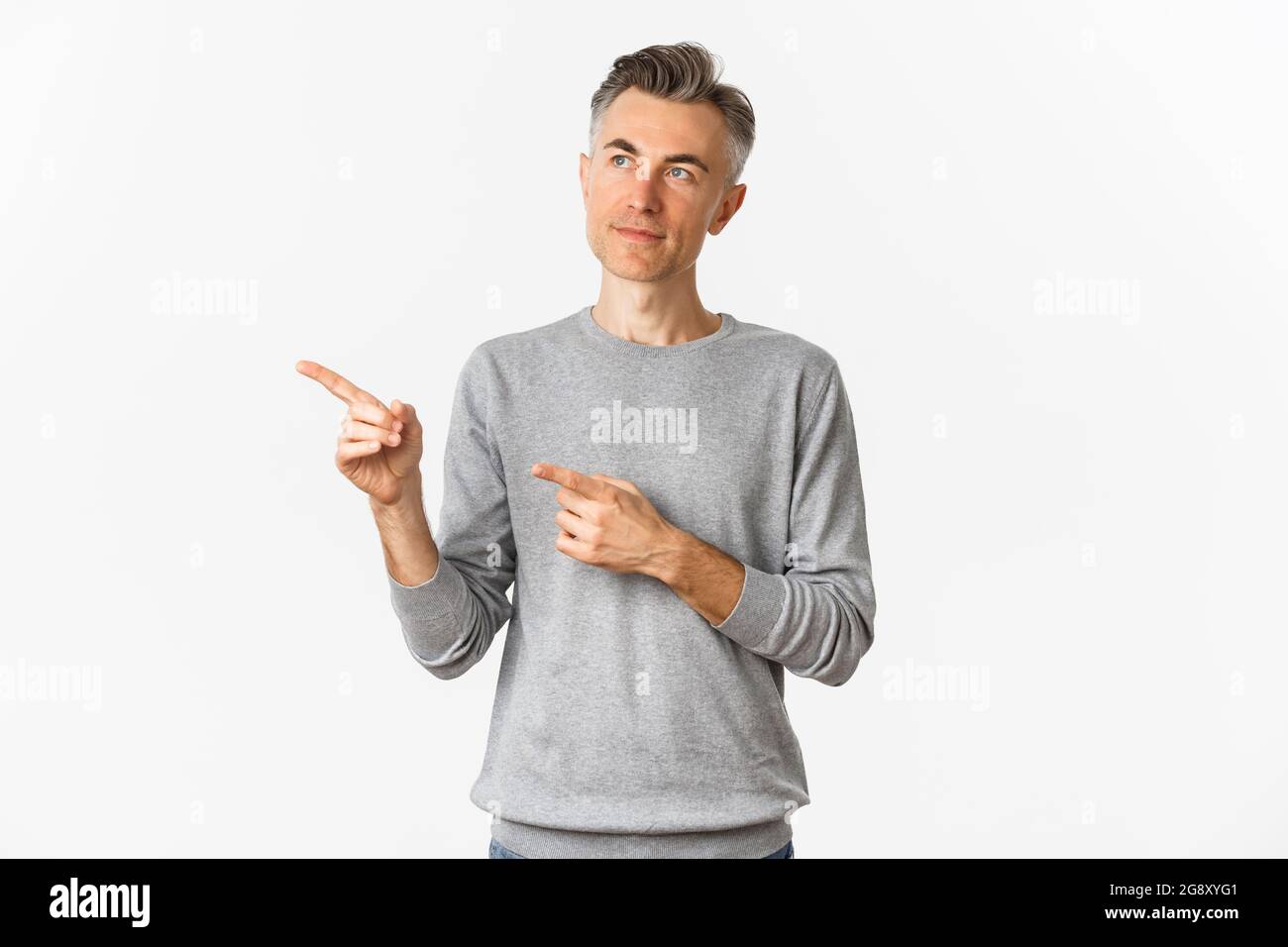 Image of thoughtful middle-aged man making choice, looking and pointing ...