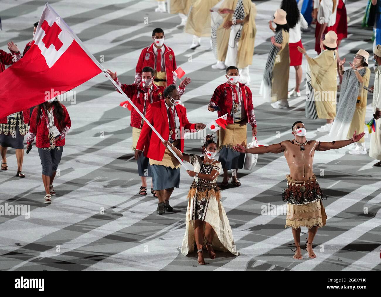 Tonga flagbearers Malia Paseka and Pita Taufatofua lead the team out ...