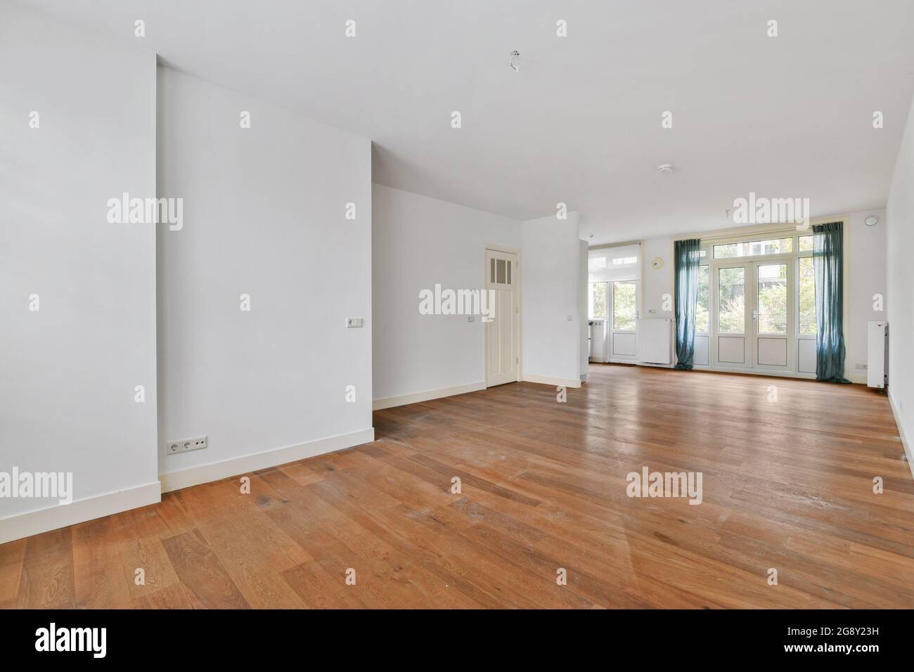 Large empty room with white walls, and a wooden floor Stock Photo - Alamy