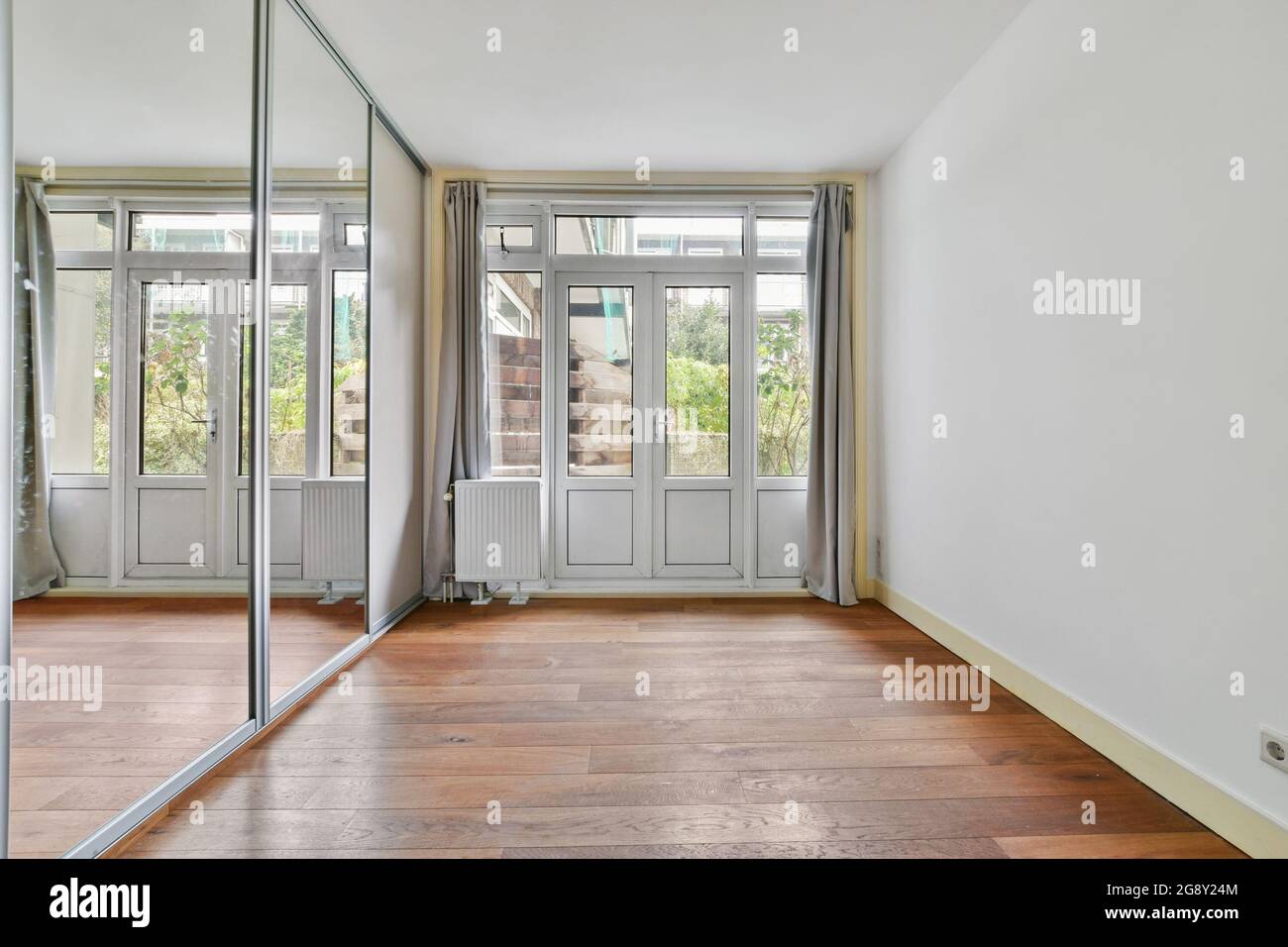Empty room with white walls, mirrors, and a wooden floor Stock Photo ...