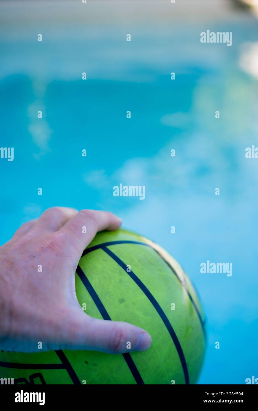 vertical photo of a hand grasping a rubber ball in the water Stock ...