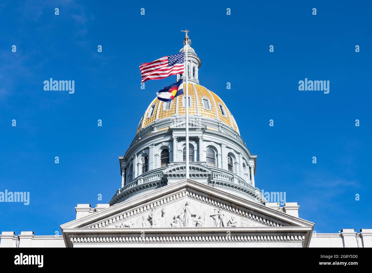 Dome of the Colorado Capitol Building with the state and american flag ...