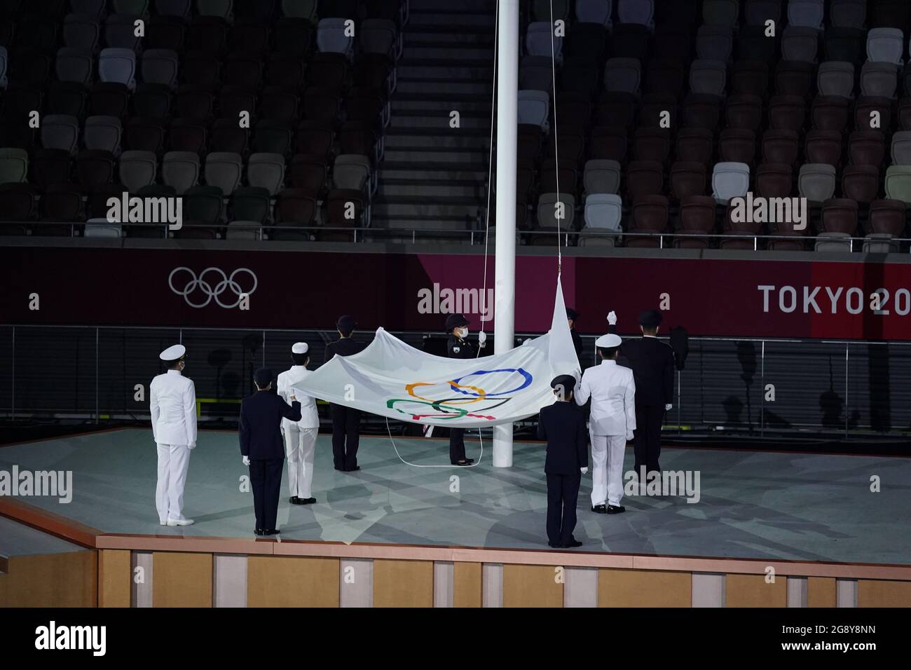 The Olympic flag is carried before being flown during the opening ...