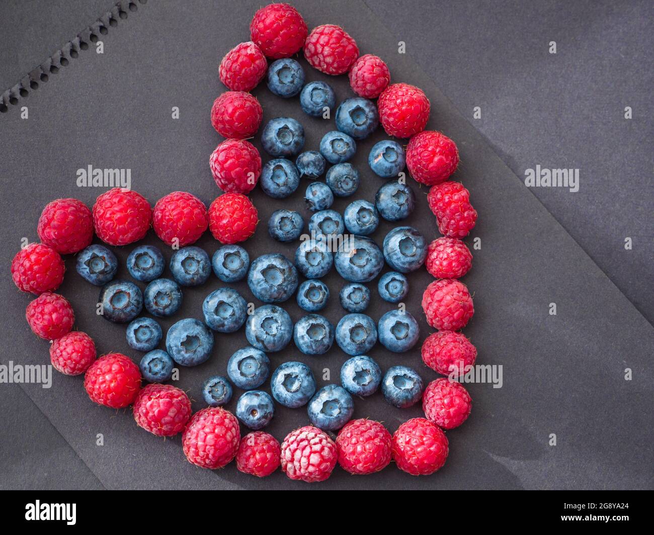 Heart shape love sign made by fresh raspberries and blueberries on ...