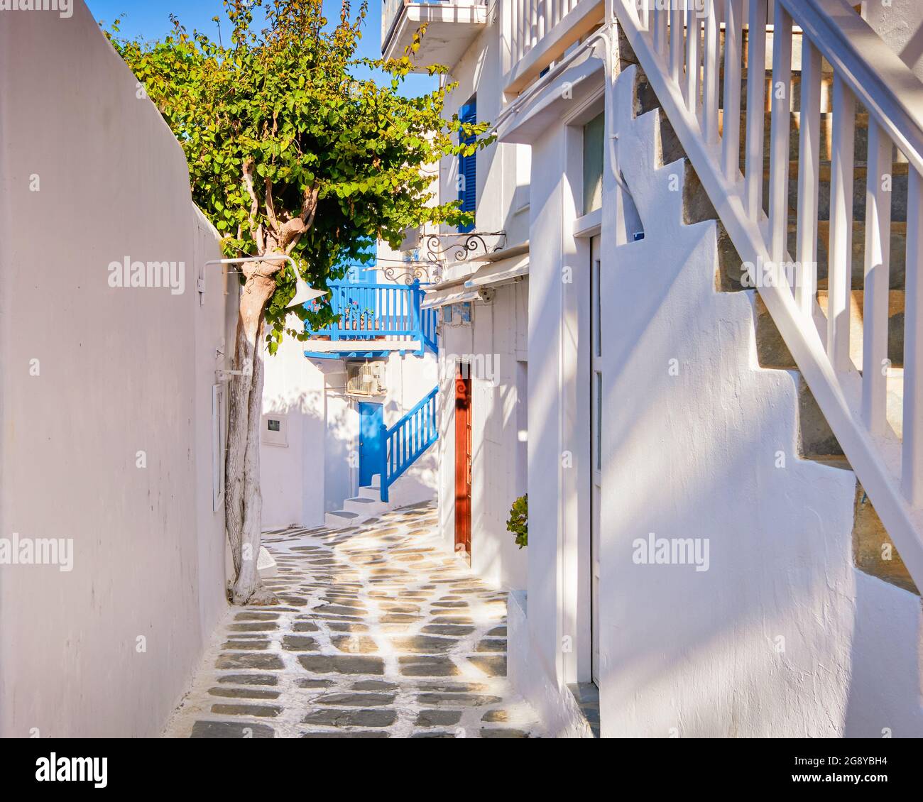 Traditional narrow cobbled streets, beautiful alleyways of Greek island town. Whitewashed houses ...
