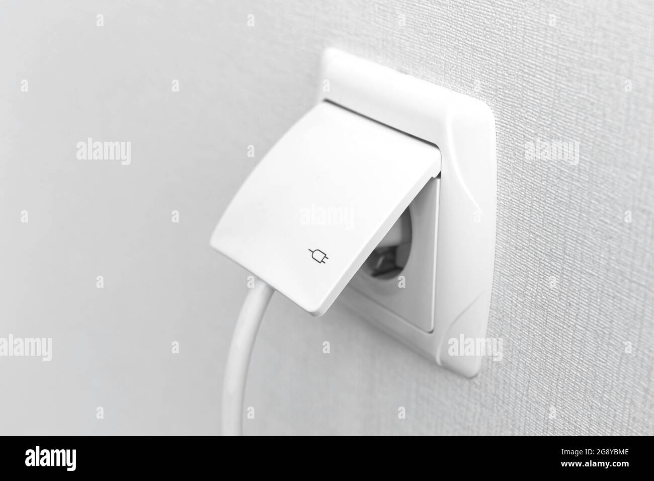 White plug into electric socket, modern interior Stock Photo - Alamy