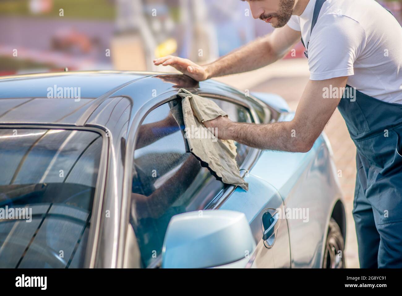 Hands of man wiping side window of car Stock Photo - Alamy