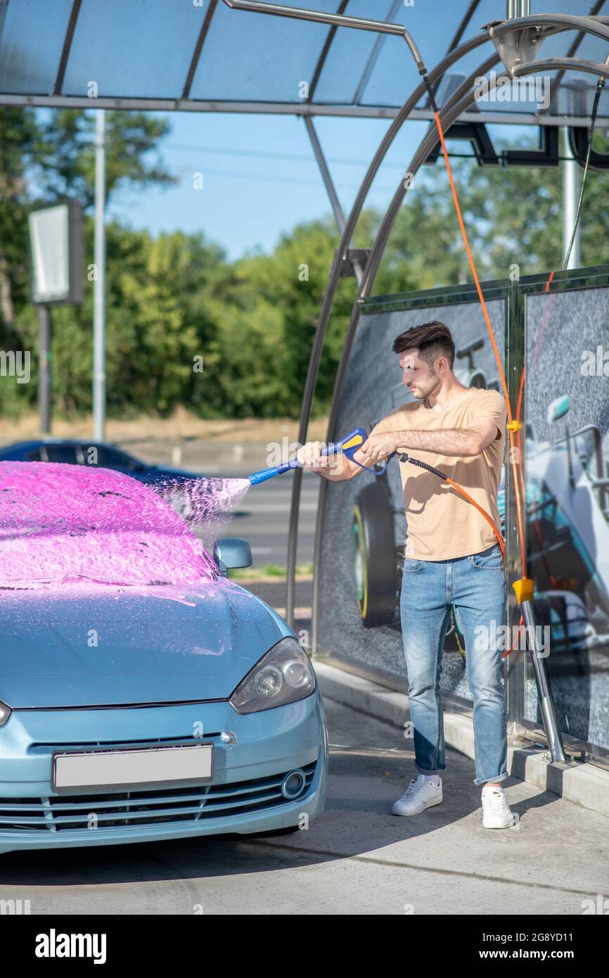 Man spraying water from hose on car Stock Photo - Alamy