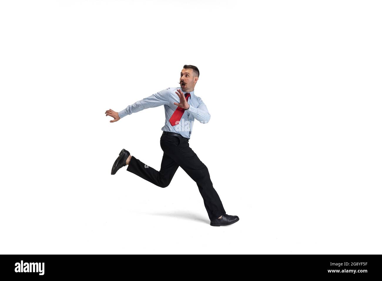 Portrait of young Caucasian man, office worker running isolated over ...