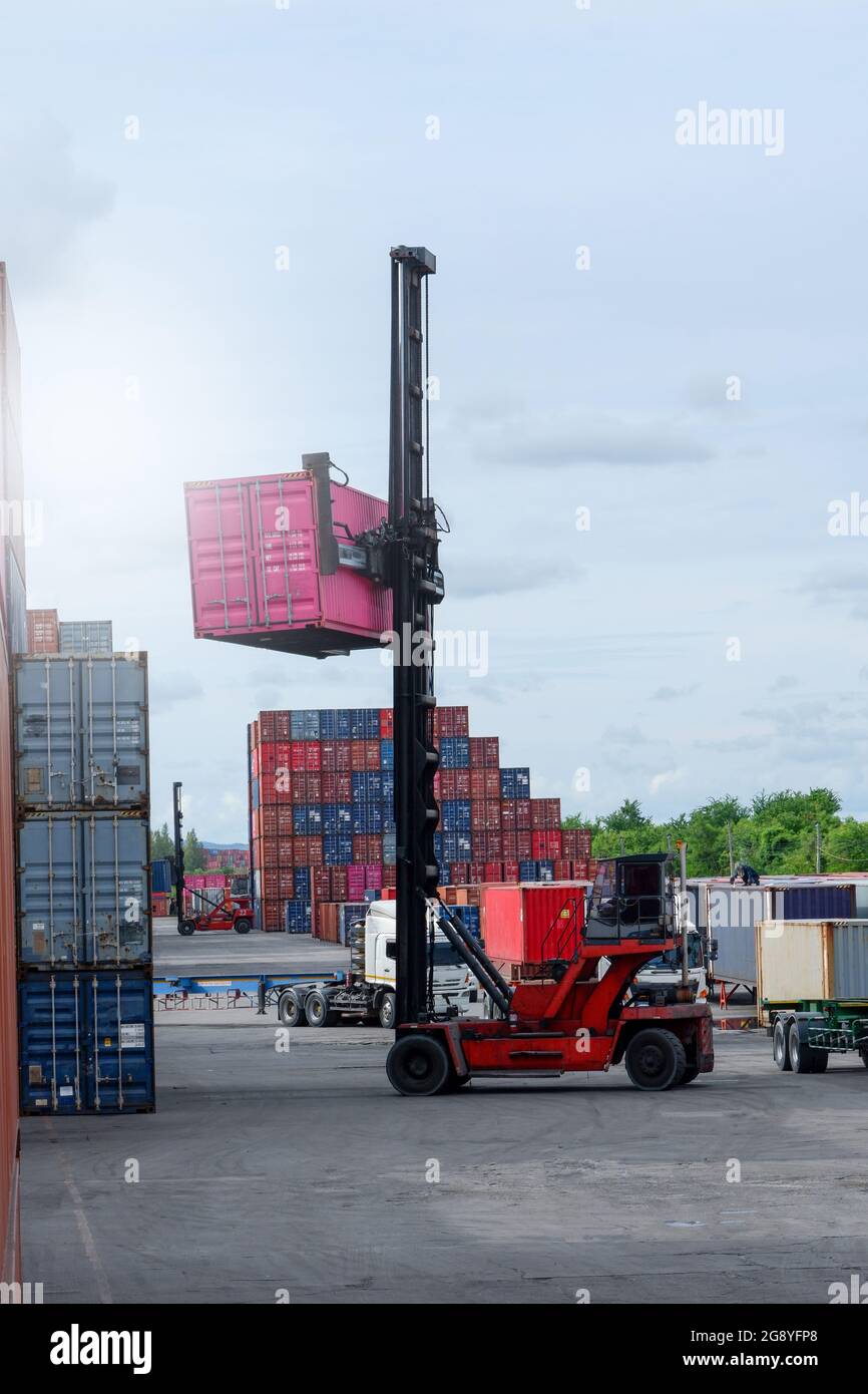 Forklift truck lifting cargo container in shipping yard or dock yard ...