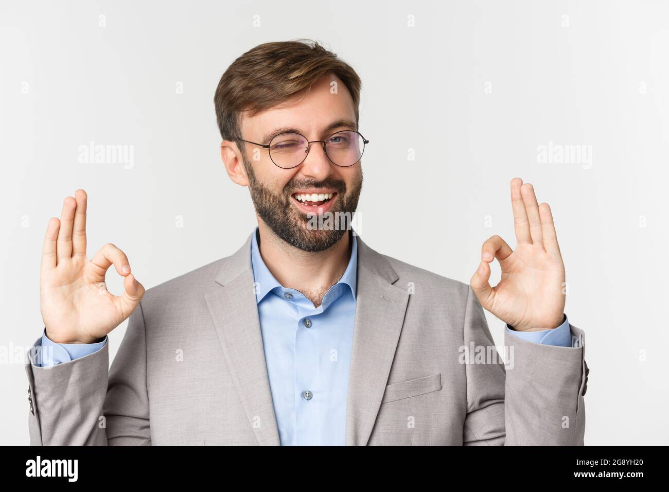 Close-up of impressed boss in gray suit and glasses, showing okay sign ...