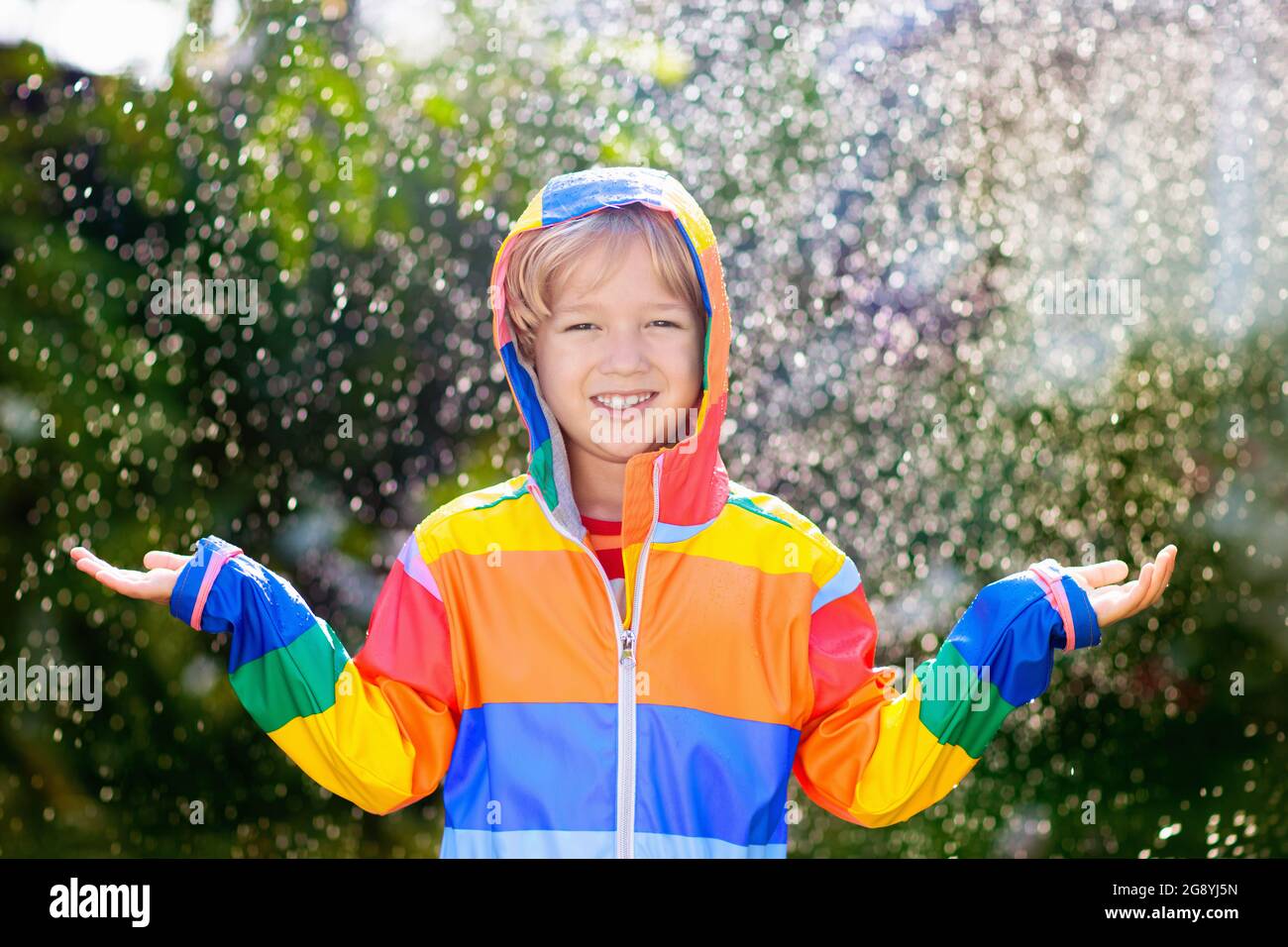 Child playing in autumn rain. Kid with umbrella. Little boy running in ...