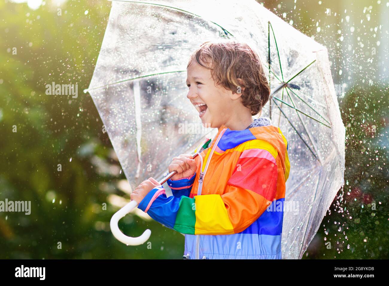 Child playing in autumn rain. Kid with umbrella. Little boy running in ...