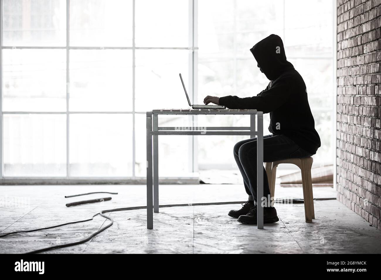 Hacker working in hideaway place and using labtop, concept for computer ...