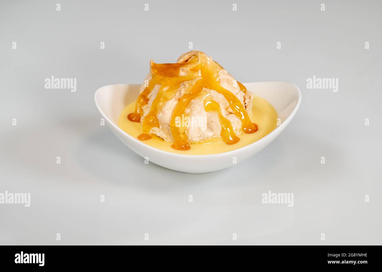 Floating island dessert made of meringue floating on vanilla custard ...