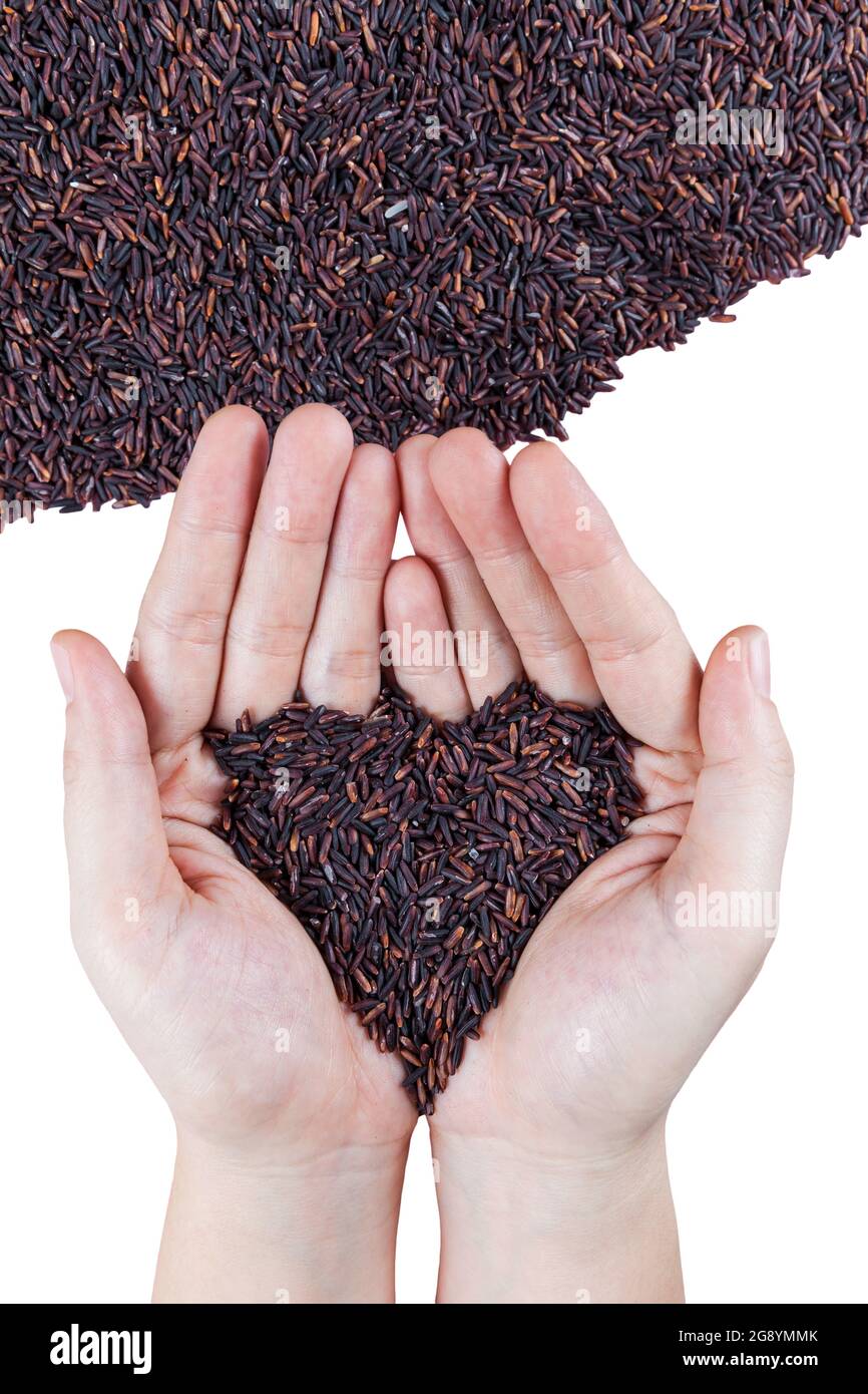 Organic rice heart-shaped on palm of asian woman hand over brown rice ...