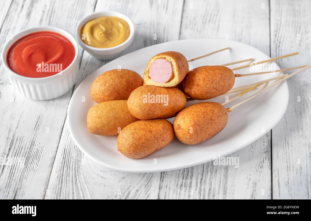 Corn dogs with dip sauces on white serving plate Stock Photo - Alamy