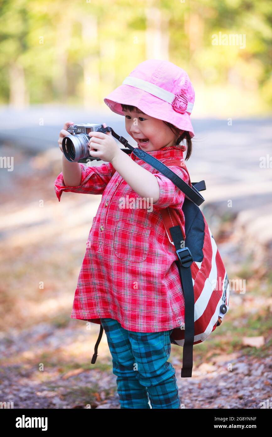 Cute little asian girl taking photos by professional digital camera in ...