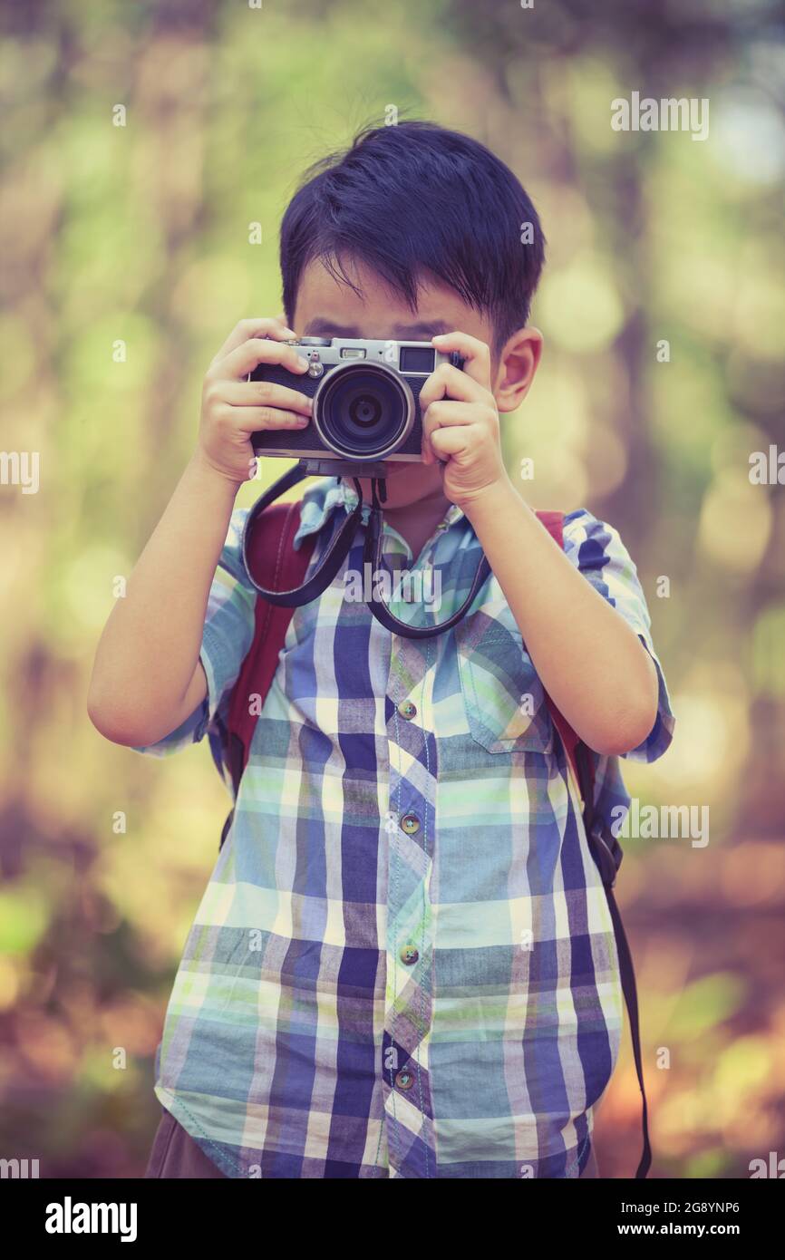 Asian boy taking photos by professional digital camera on blurred ...