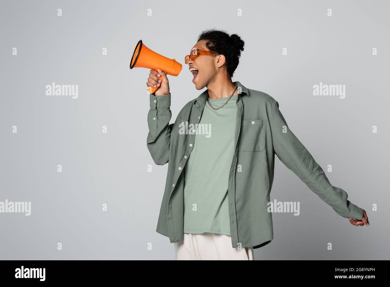 trendy african american guy shouting in orange megaphone isolated on ...