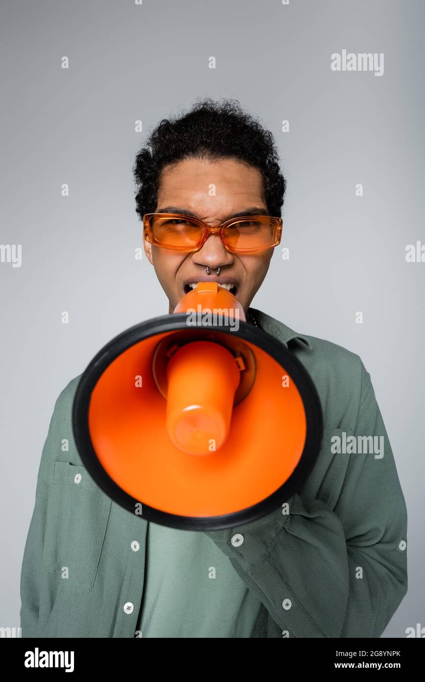 front view of trendy african american man screaming in loudspeaker ...