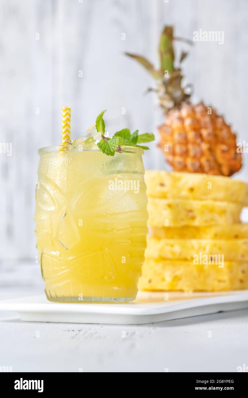 Glass of pineapple tiki style cocktail on white background Stock Photo ...
