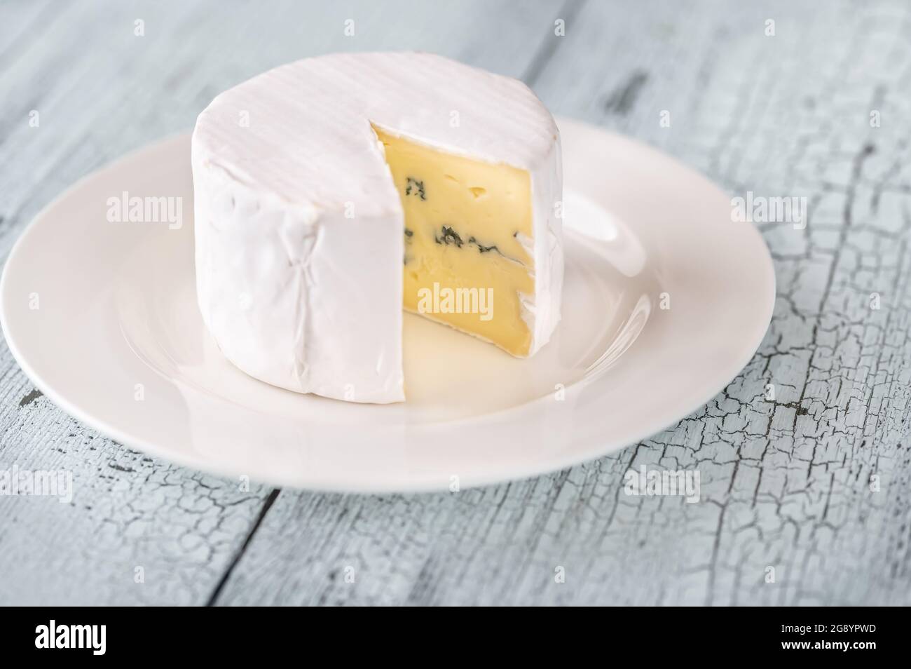 Blue cheese under a rind of white mould on the plate Stock Photo - Alamy
