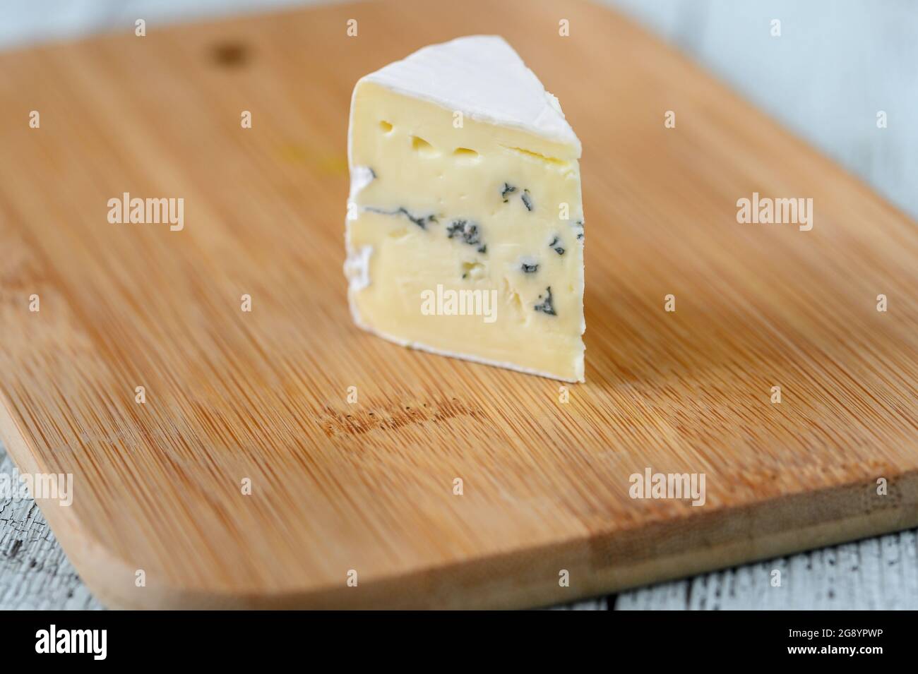 Wedge of blue cheese under a rind of white mould Stock Photo - Alamy