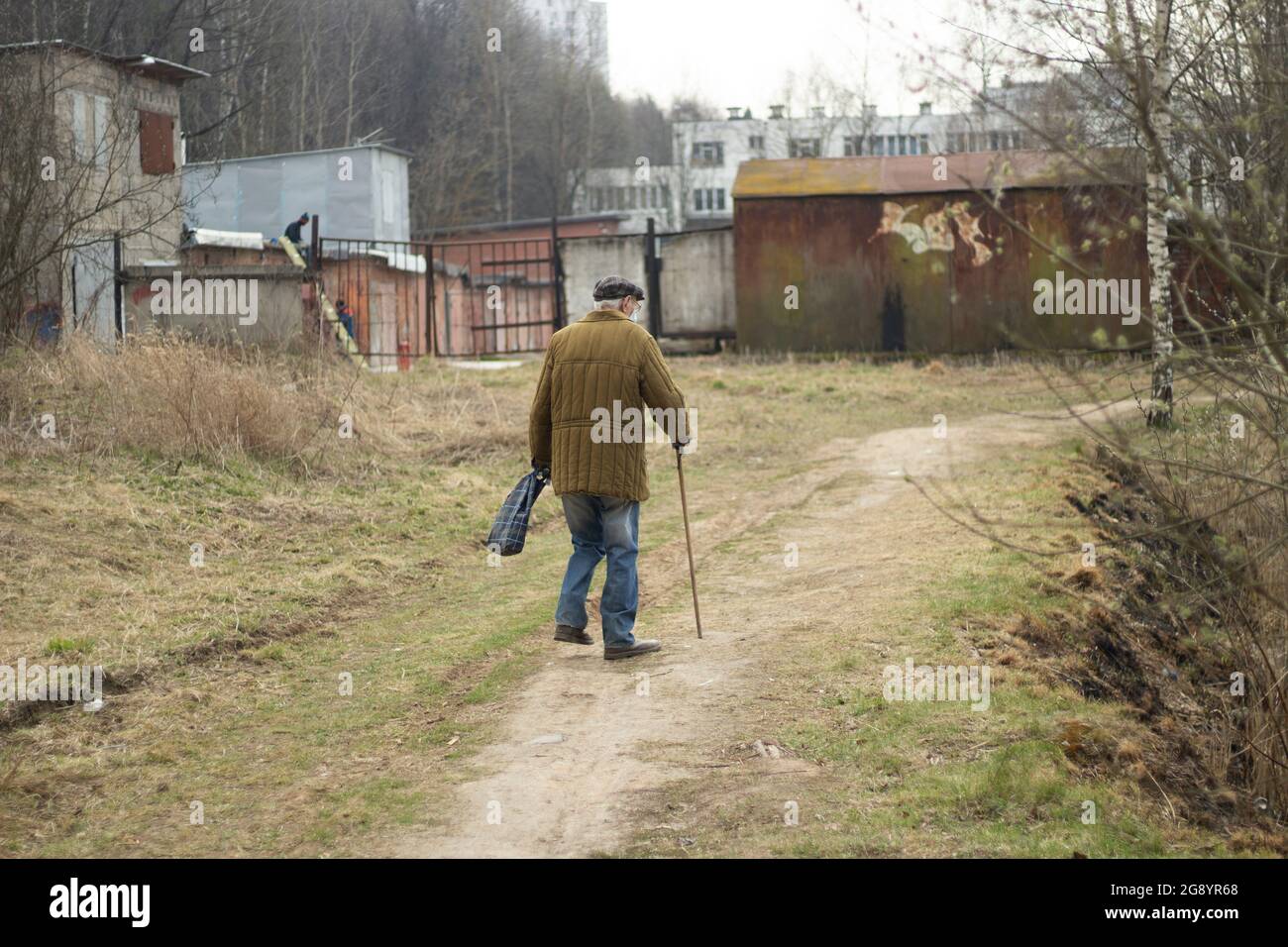 Retired in Russia. The old man walks down the street. Poor clothes on ...