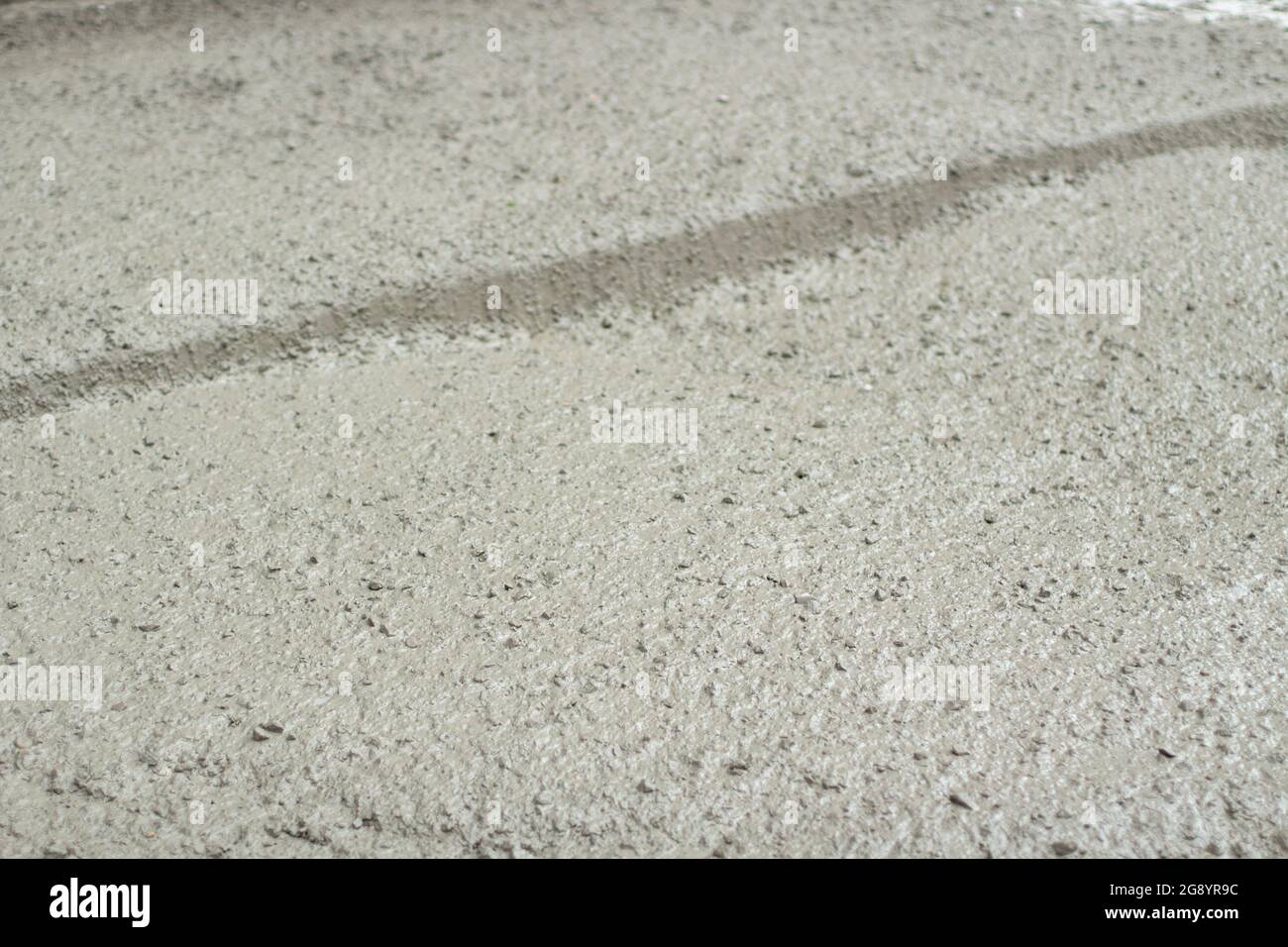 Liquid cement at a construction site. Cement spilled onto the road. The ...