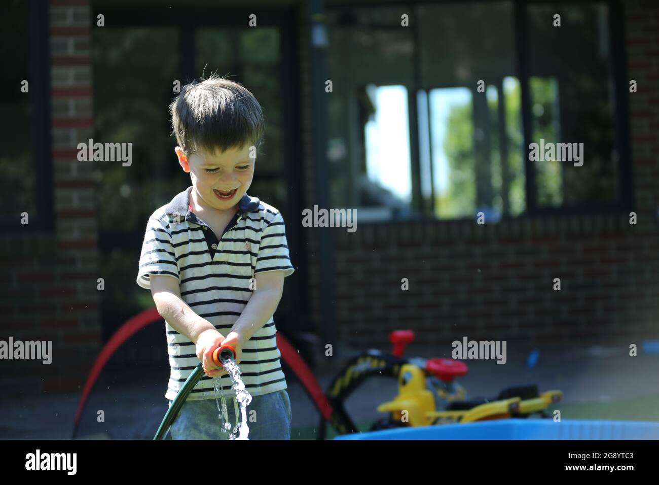 Children playing water hose on hi-res stock photography and images - Alamy