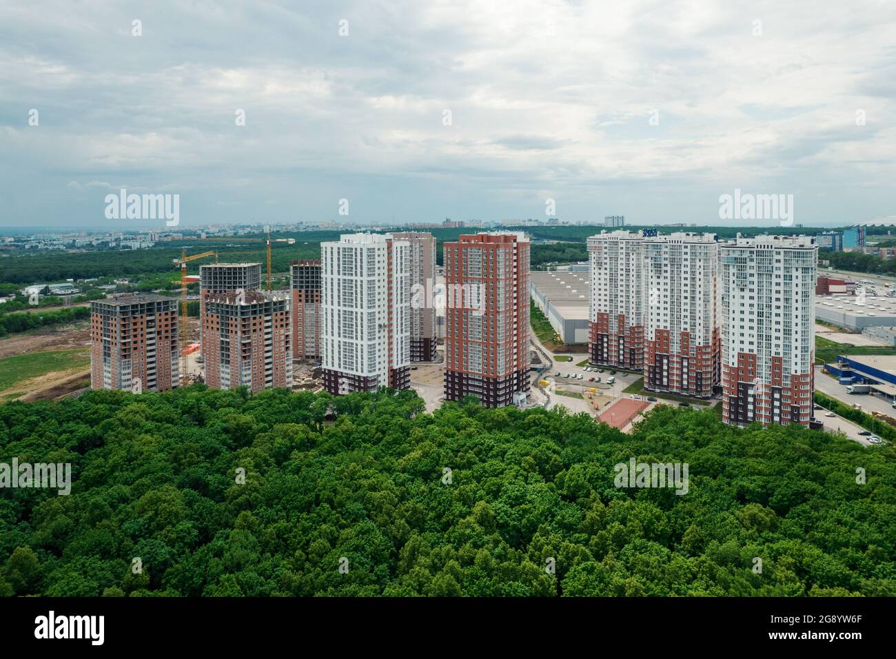 Construction yard of multistory living building with hoisting cranes ...