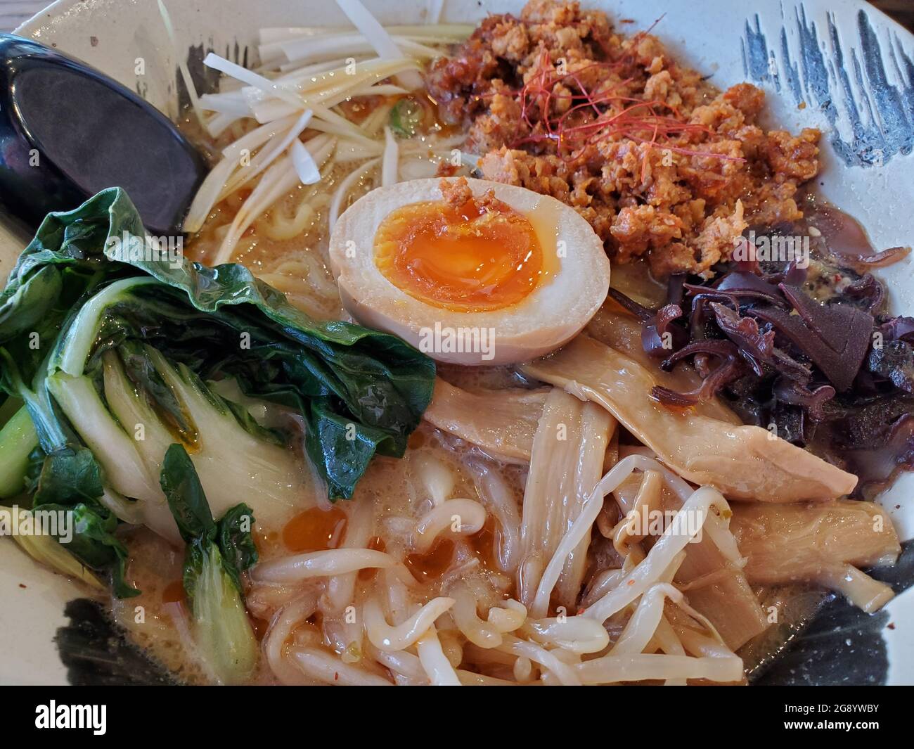 High-angle close-up of a bowl of ramen soup, with half a ramen egg ...