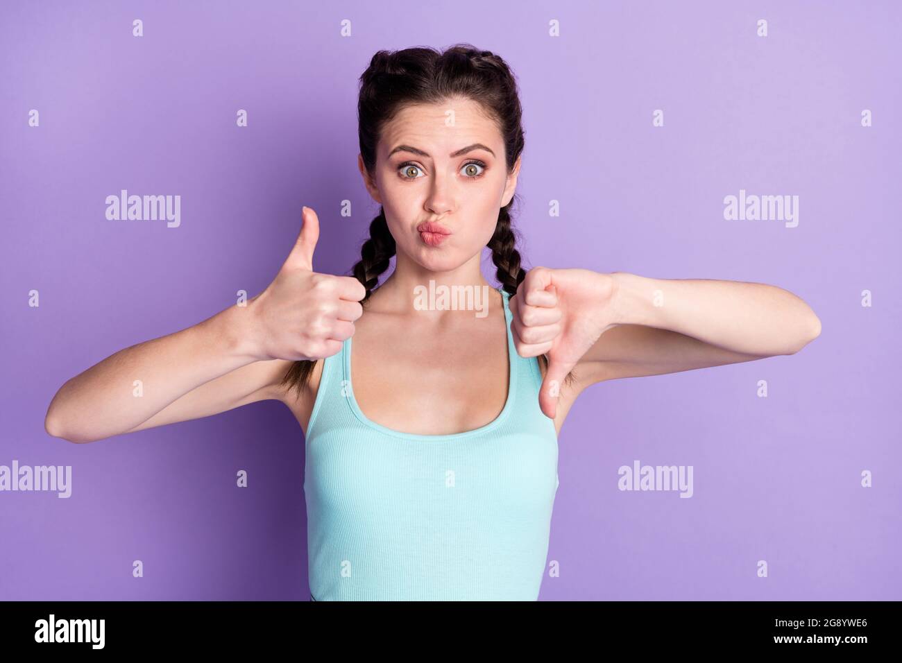 Photo of unsure puzzled young woman make hands thumbs up down dilemma ...